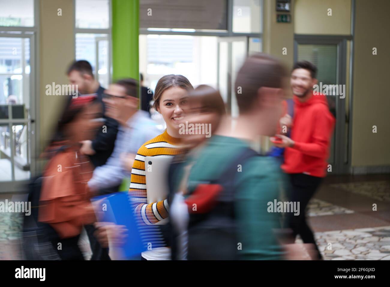 portrait of a happy young student getting ready for class while waiting ...