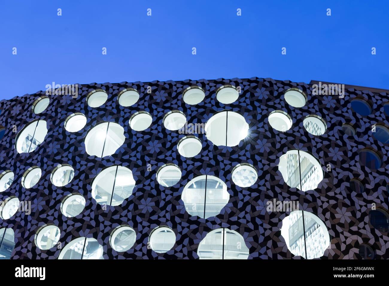 bright lights beam through a lot of round glass windows in different ...