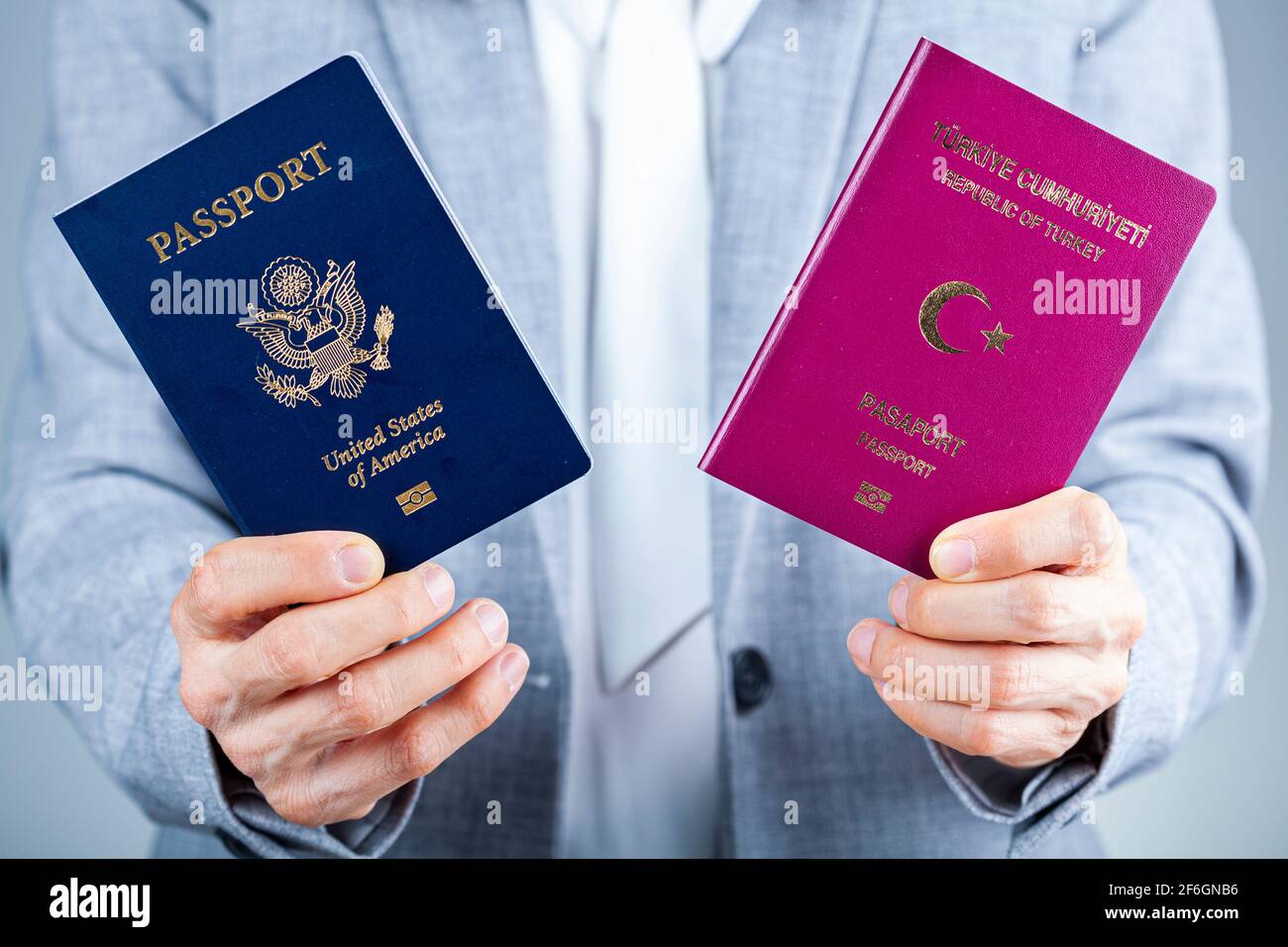 A woman in formal clothes is holding Turkish and US passports. Concept ...