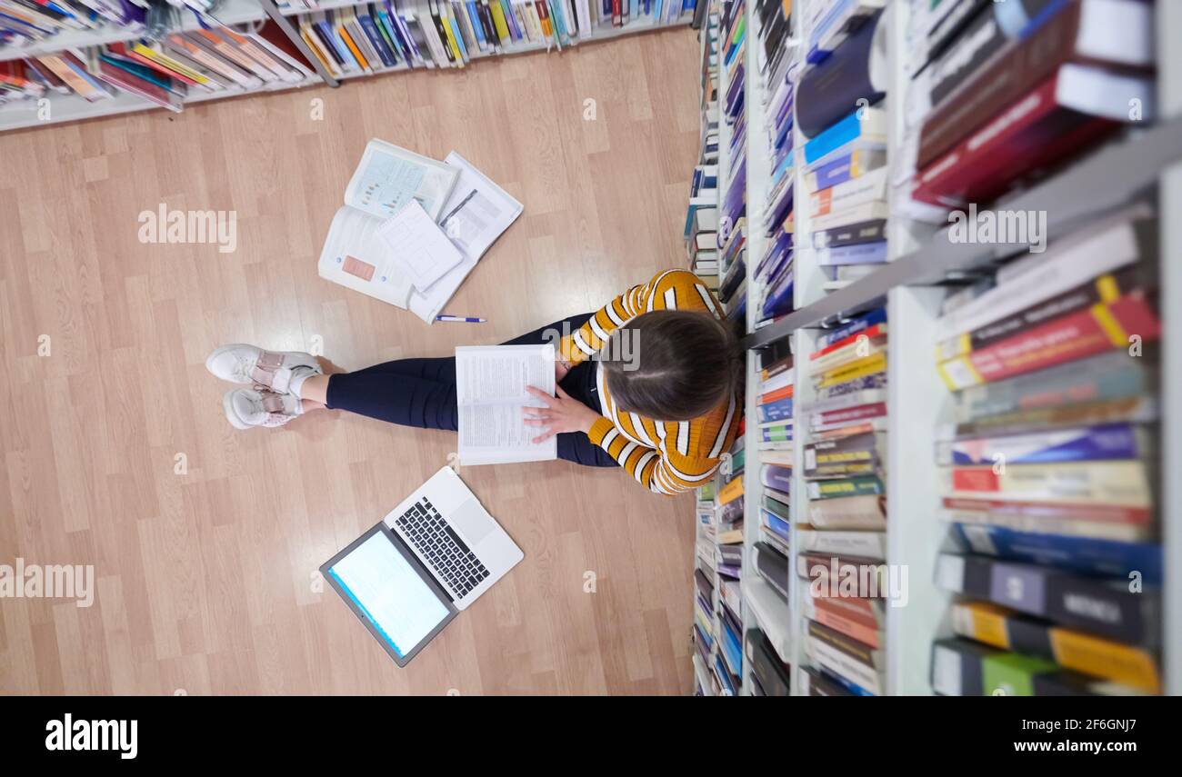 student taking notes from a book at library. Young woman sittingin in ...