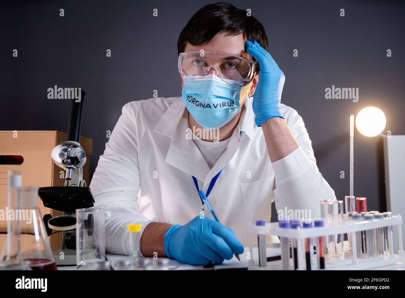 Young doctor very tired and infected with covid 19, upset holds his ...