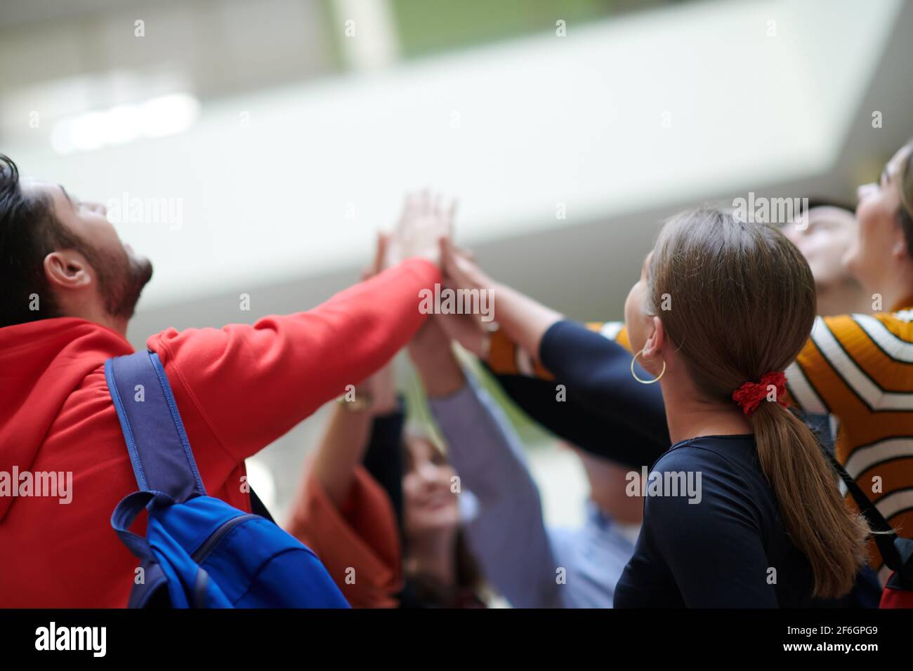 Happy Students Putting their Hands Together in the Air Inside the ...