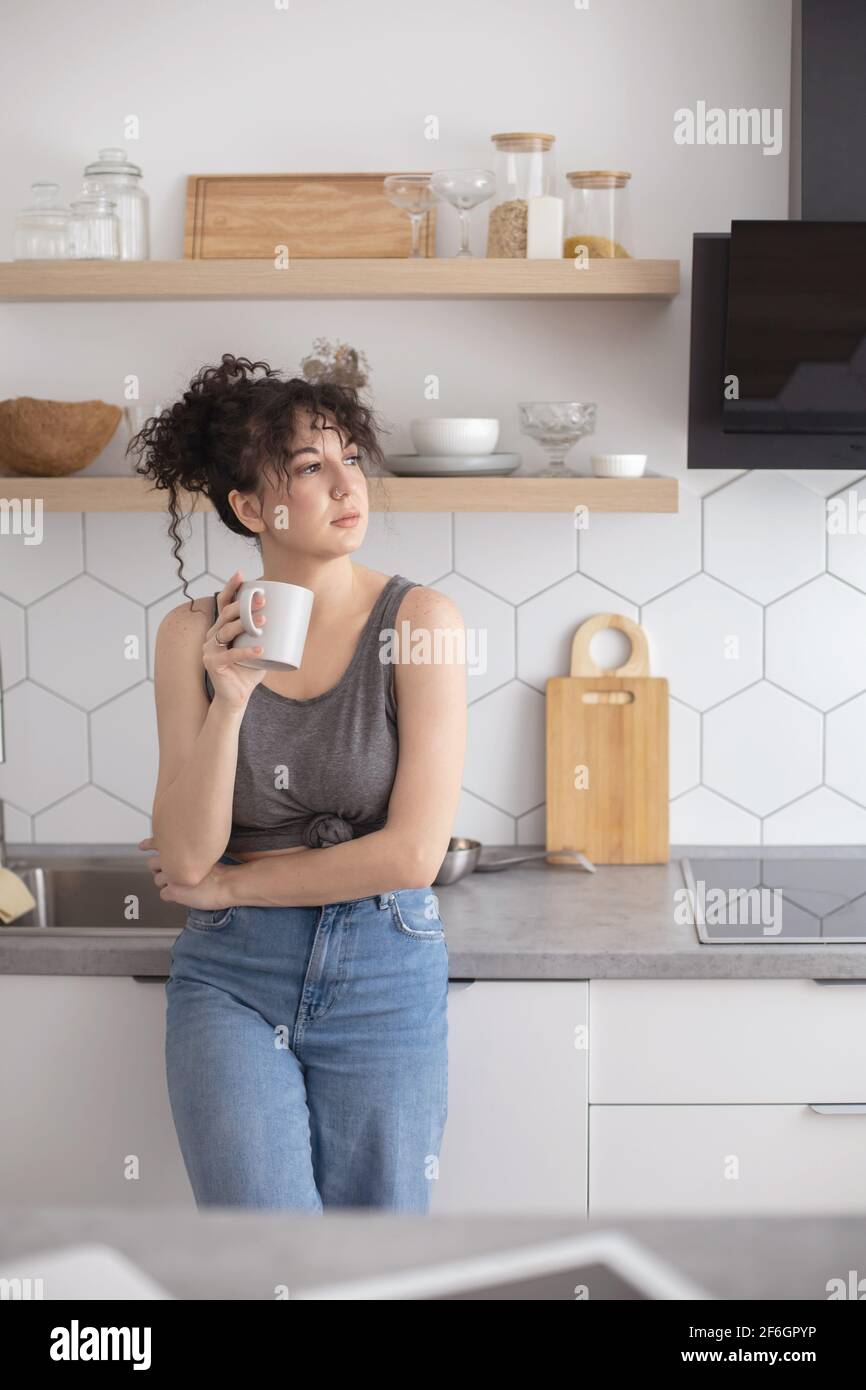 Pleasant domestic woman relaxing at modern kitchen chatting use ...