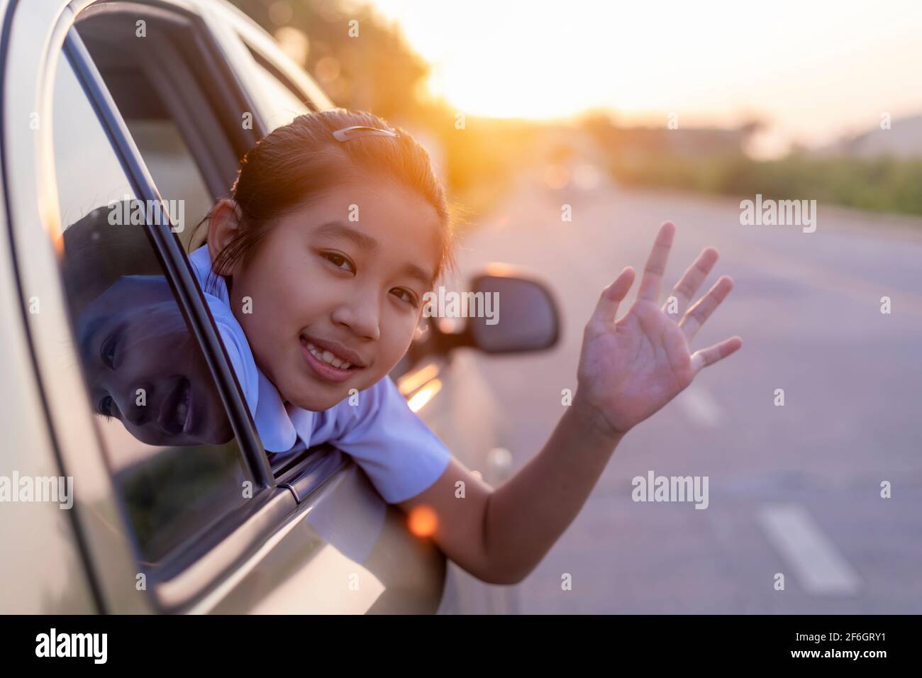 On the way to school, the little girl stretched out his hand from the ...