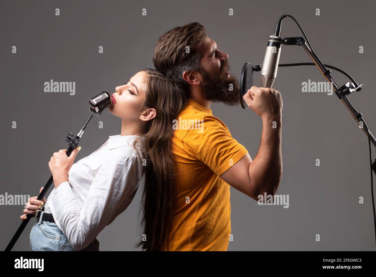 Boy and girl with excited faces enjoy music. Couple in recording studio ...