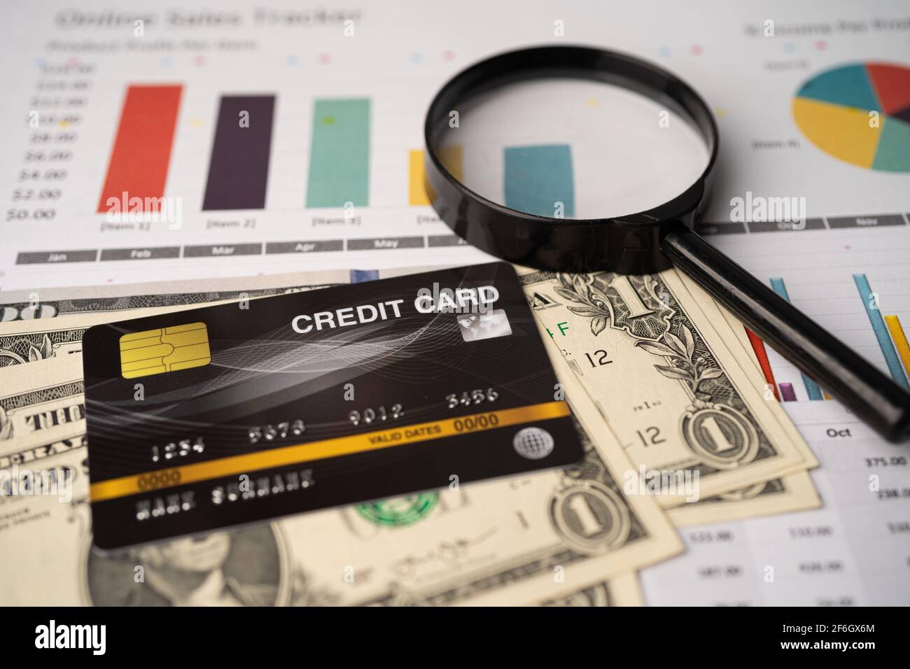 Credit card model on dollar banknotes with chart and graph paper ...