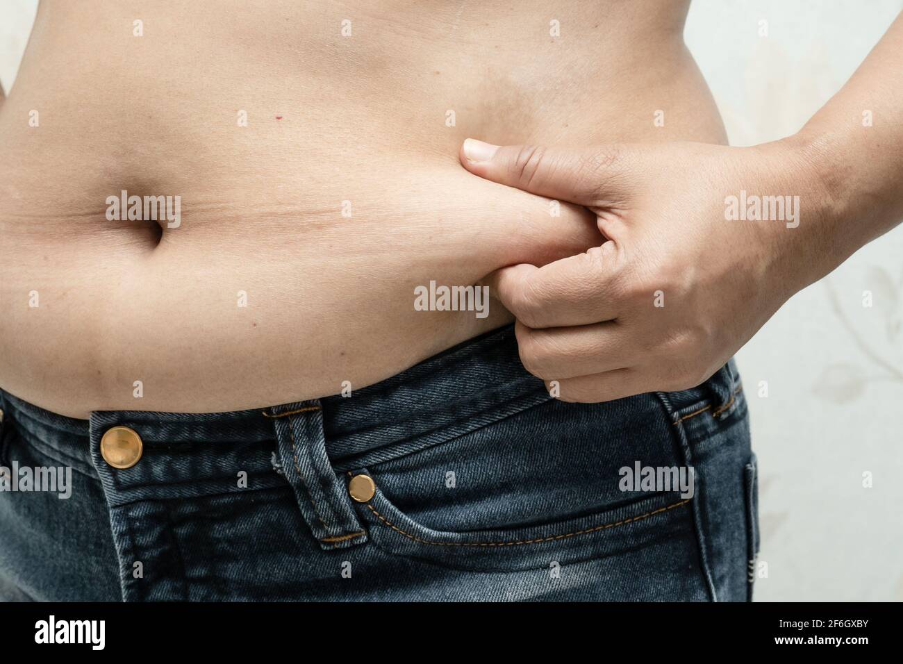 Overweight Asian woman show and use hand to squeeze fat belly Stock ...