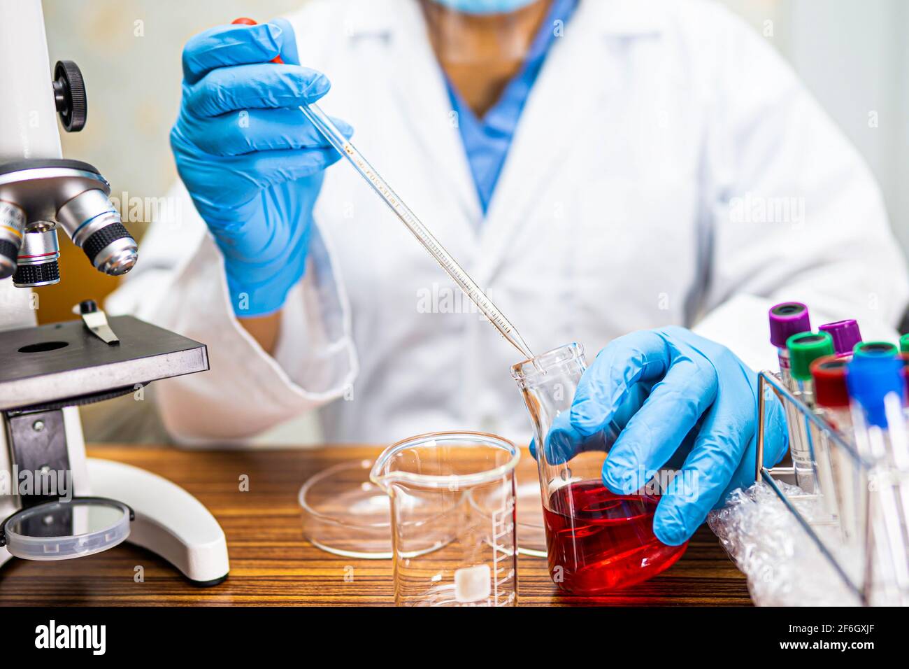 Scientist with microscope and erlenmeyer flask, conical flask glassware ...