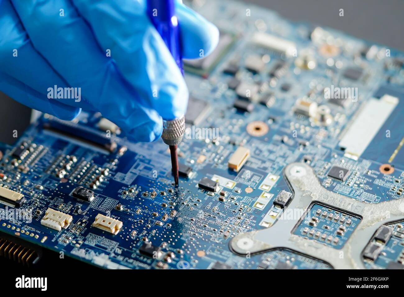 technician repairing inside of hard disk by soldering iron. Integrated ...