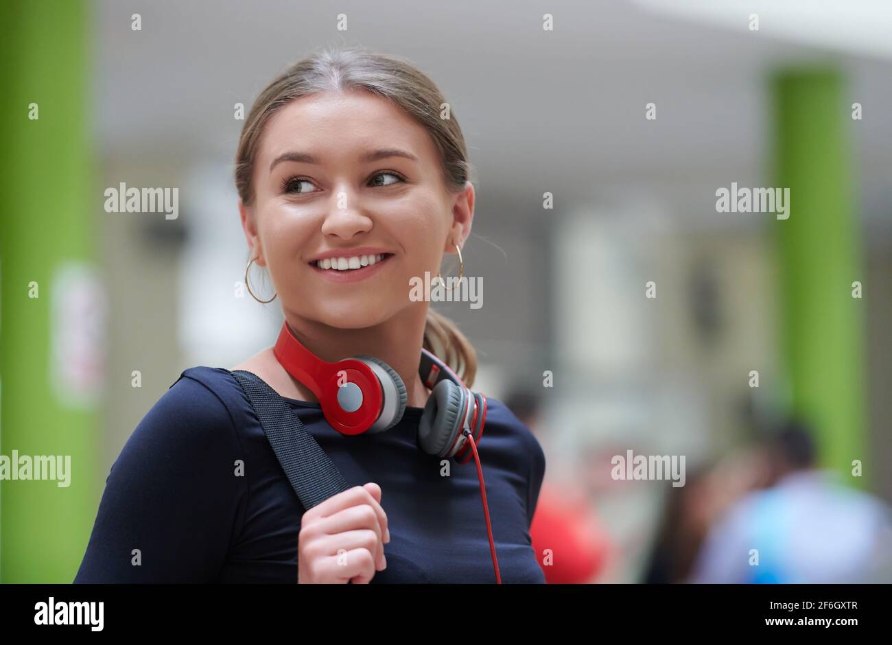 portrait of a happy young student getting ready for class while waiting ...