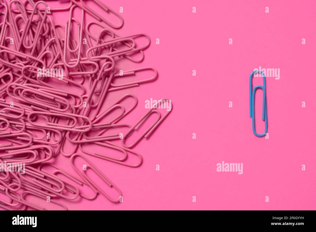 One blue paper clip and pile of pink paper clips Stock Photo - Alamy