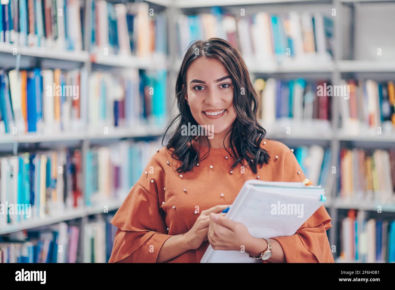 Reading a book in library. Young attractive librarian reading a book ...