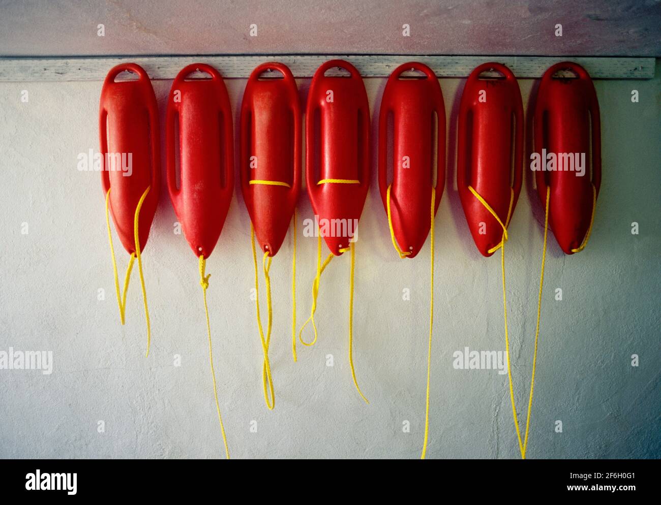 Row of red lifeguard floats hanging on wall Stock Photo - Alamy