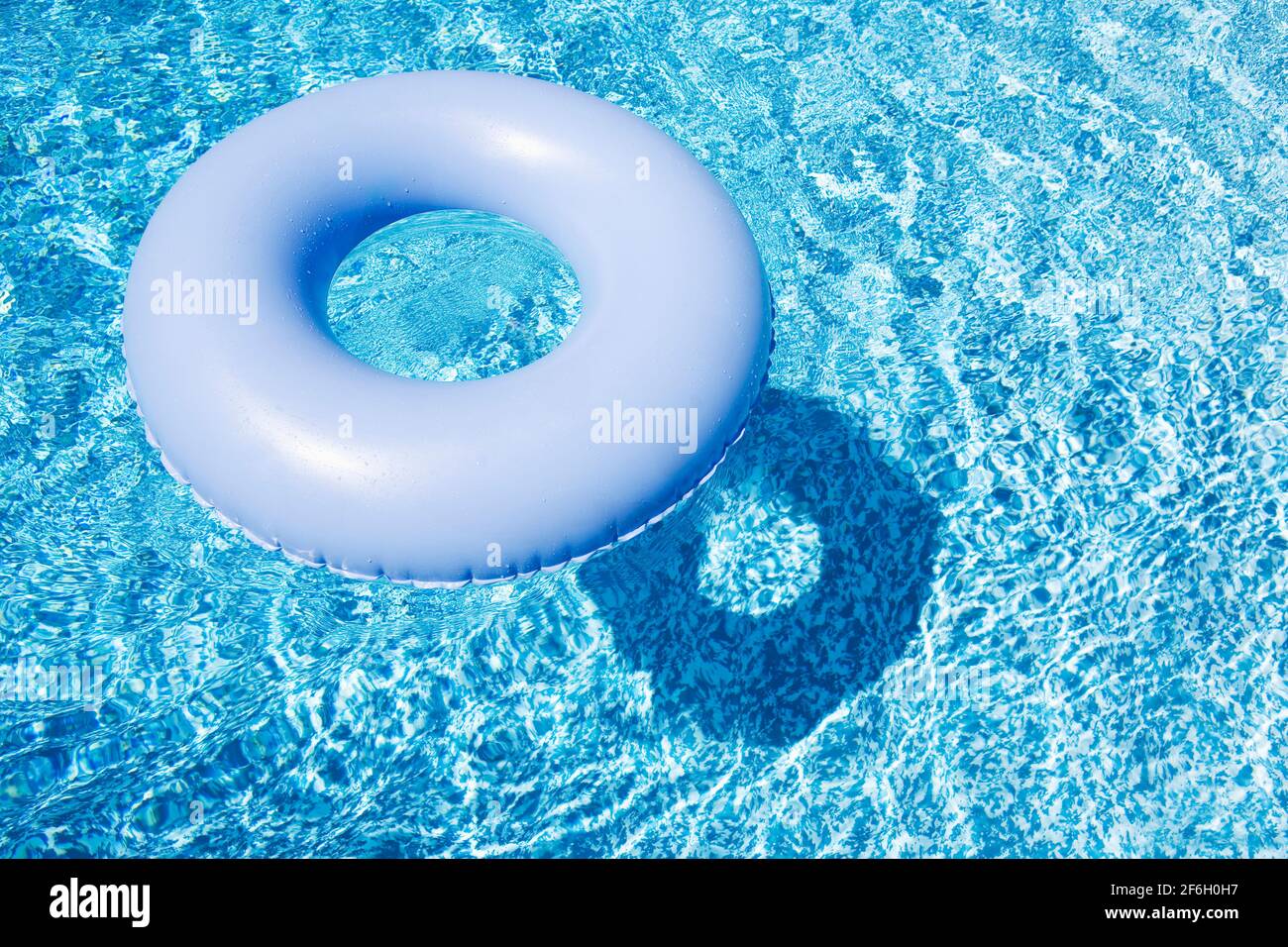 Blue inflatable ring floating on pool water surface Stock Photo - Alamy
