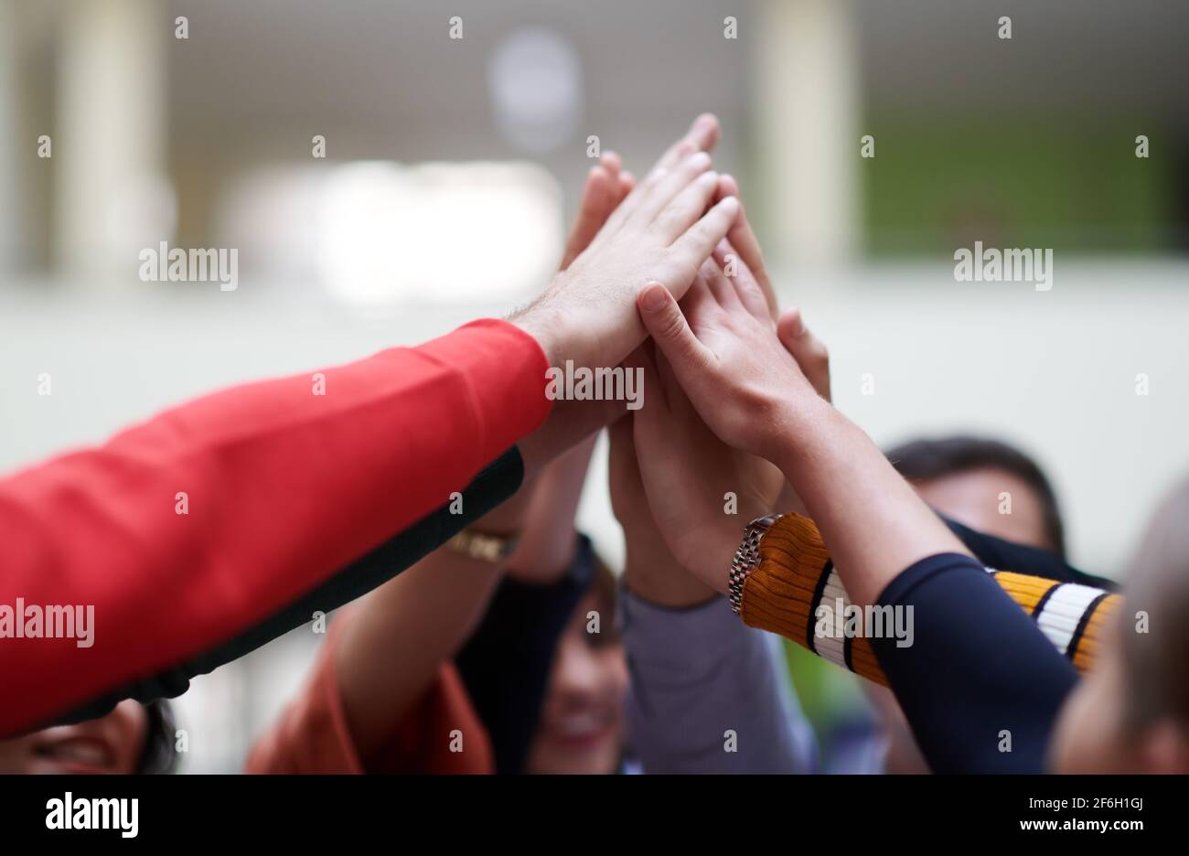 Happy Students Putting their Hands Together in the Air Inside the ...