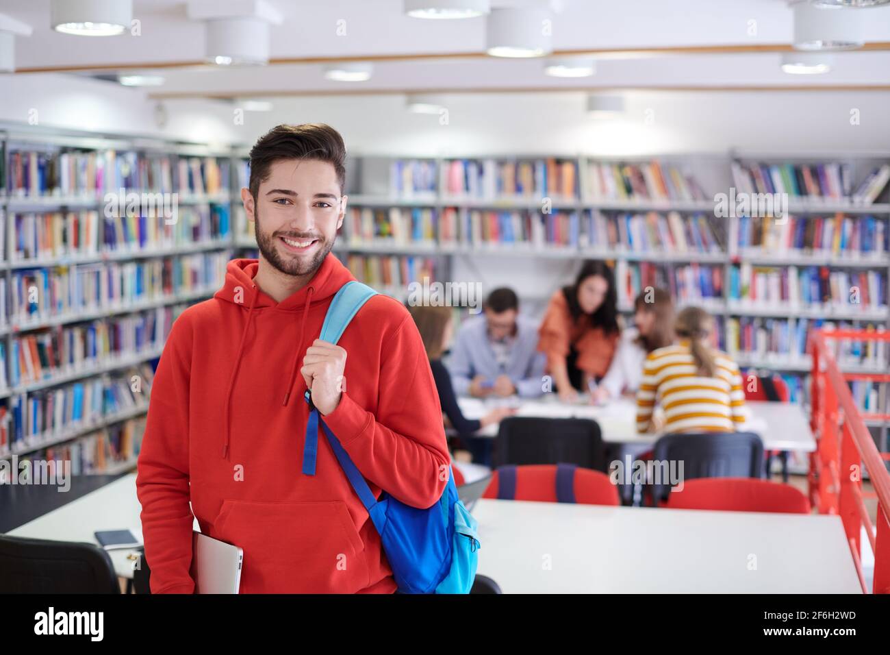 a young student is standing in front of the school library with a ...