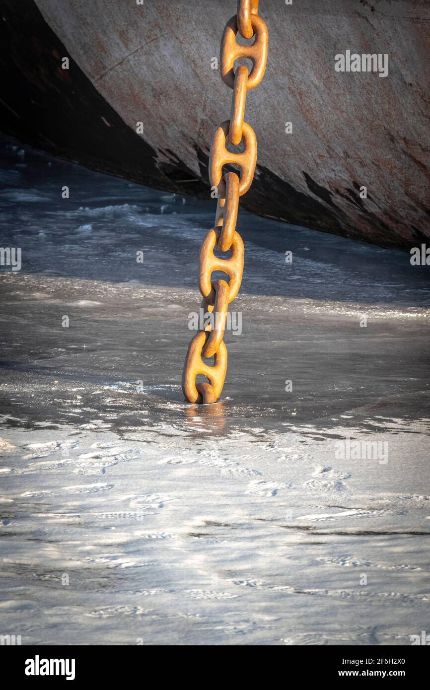 A rusty chain of an old anchor frozen into the ice Stock Photo - Alamy