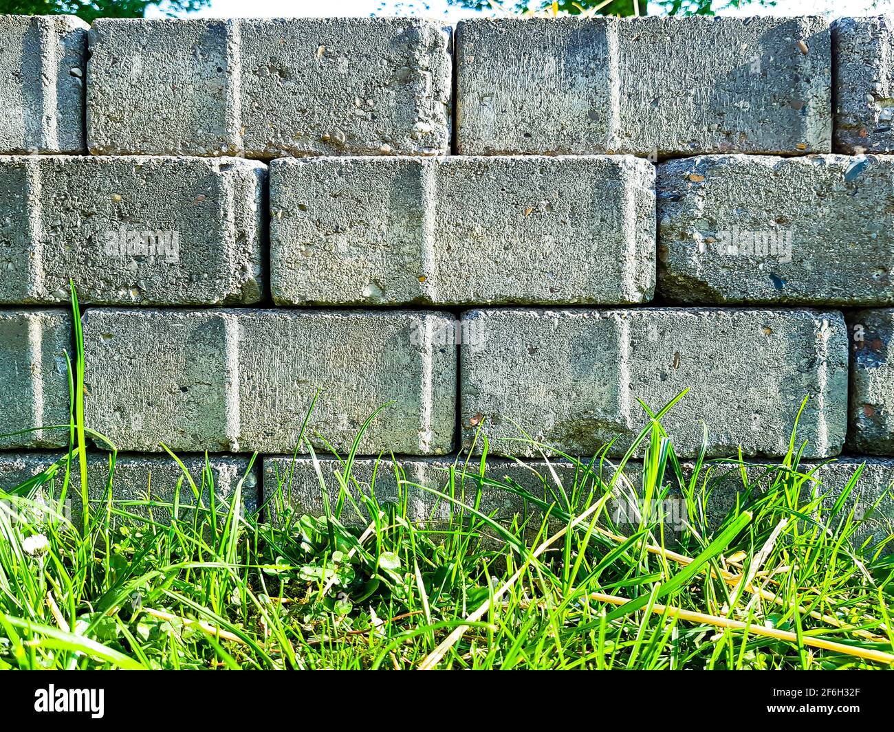 Dry stone wall bricks pavement stones concrete gray stacked masonry boundary, fence border grass ...