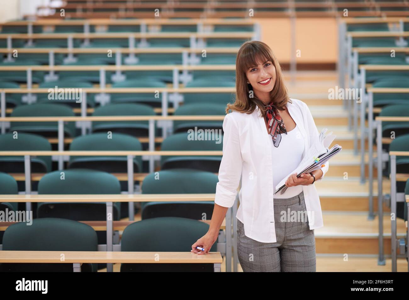 a beautiful female student uses a notebook and pen for school projects ...