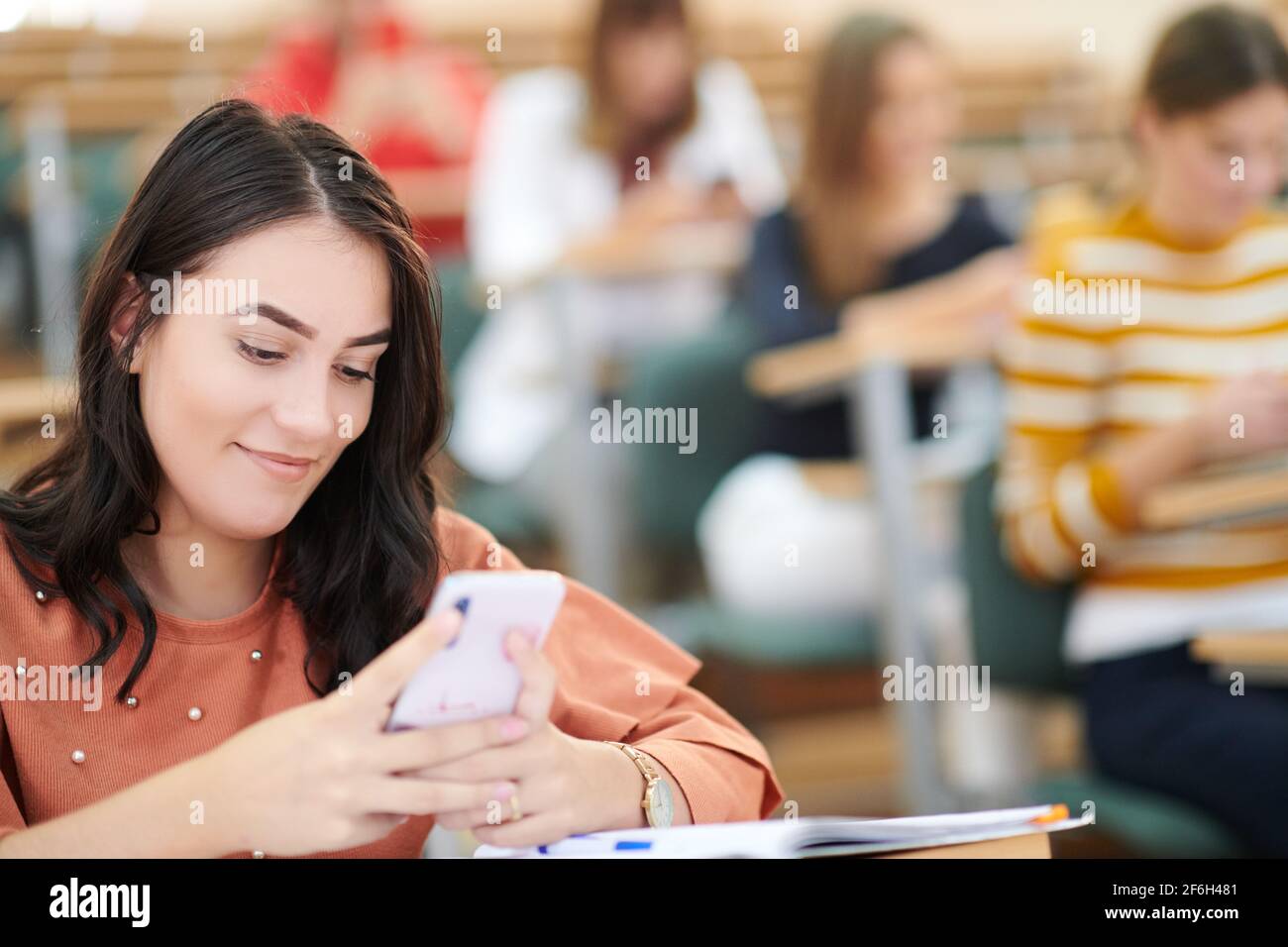 female female students use a smartphone during classroom instruction ...