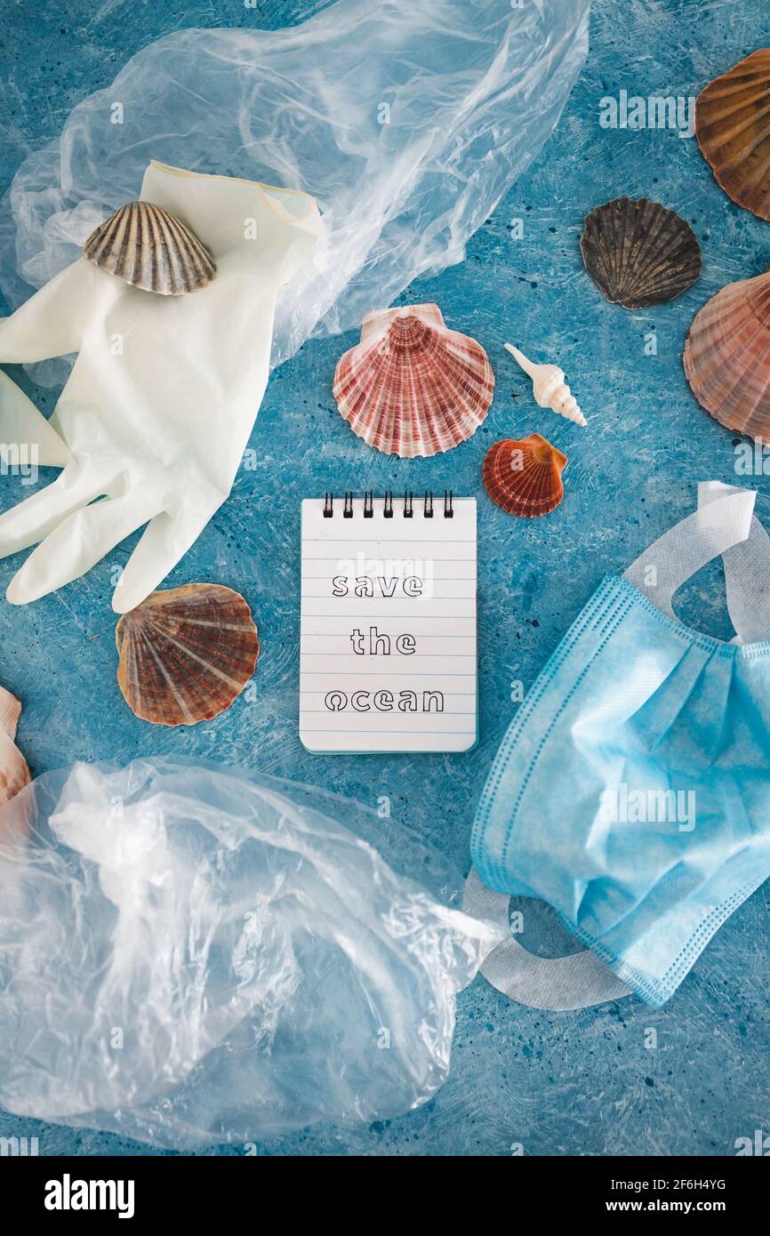 save the ocean text on blue bakground with sea shells and plastic ...