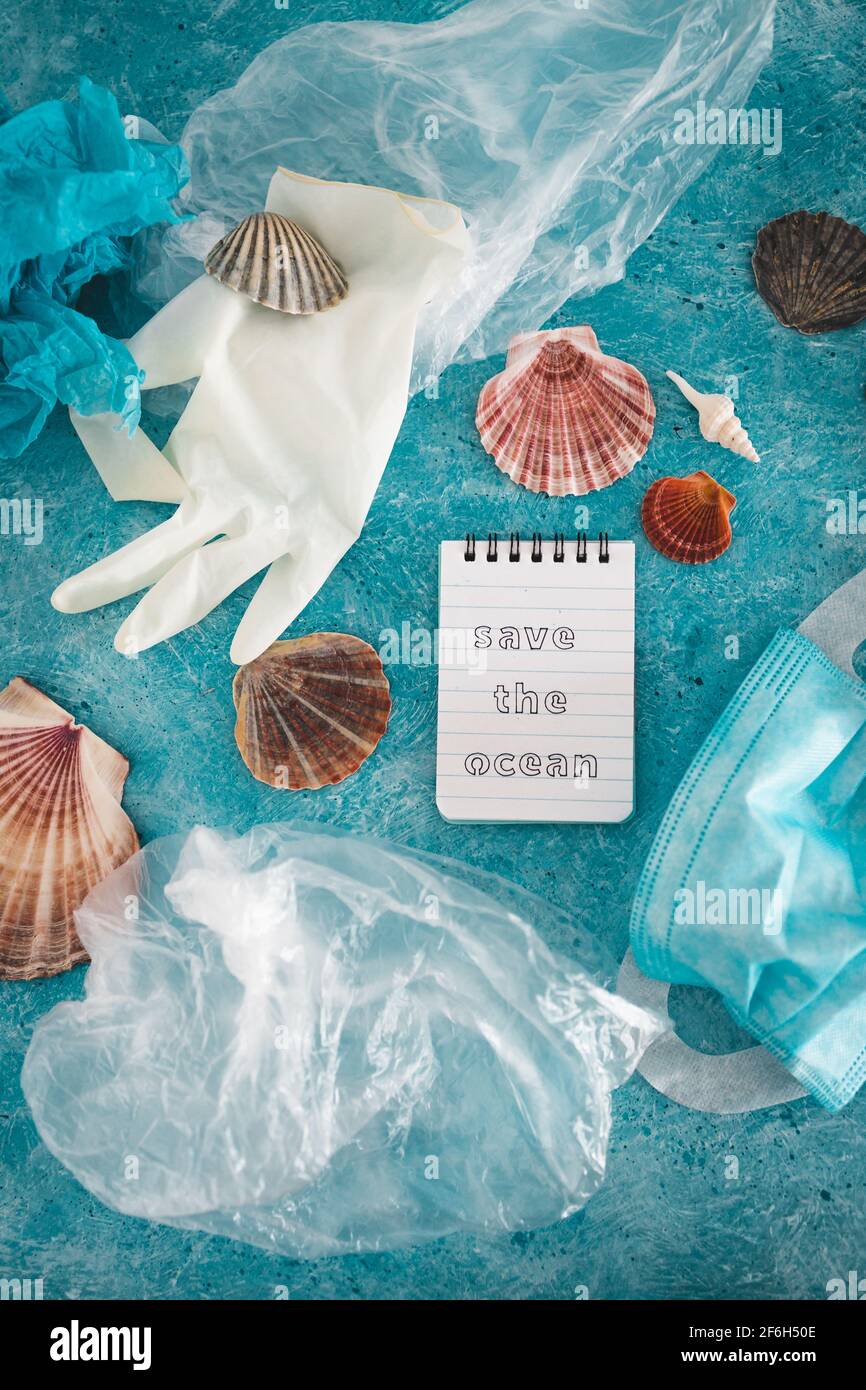 save the ocean text on blue bakground with sea shells and plastic ...