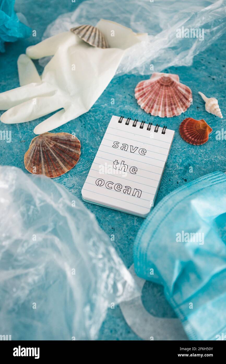 save the ocean text on blue bakground with sea shells and plastic ...