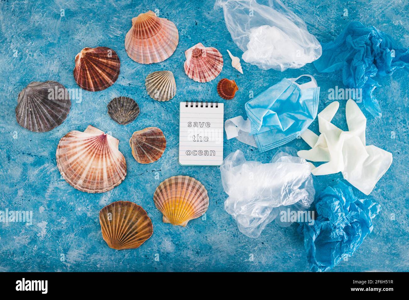 save the ocean text on blue bakground with sea shells and plastic ...