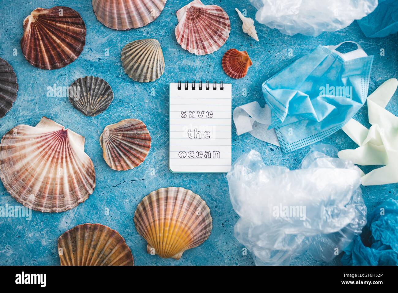 save the ocean text on blue bakground with sea shells and plastic ...