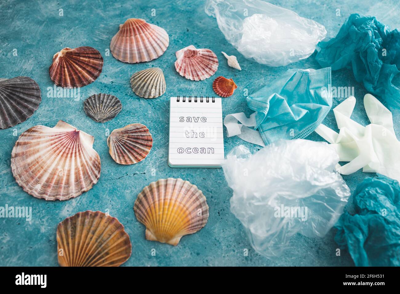 save the ocean text on blue bakground with sea shells and plastic ...
