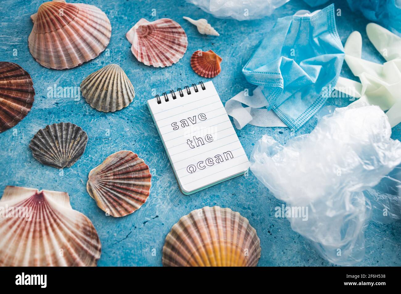 save the ocean text on blue bakground with sea shells and plastic ...