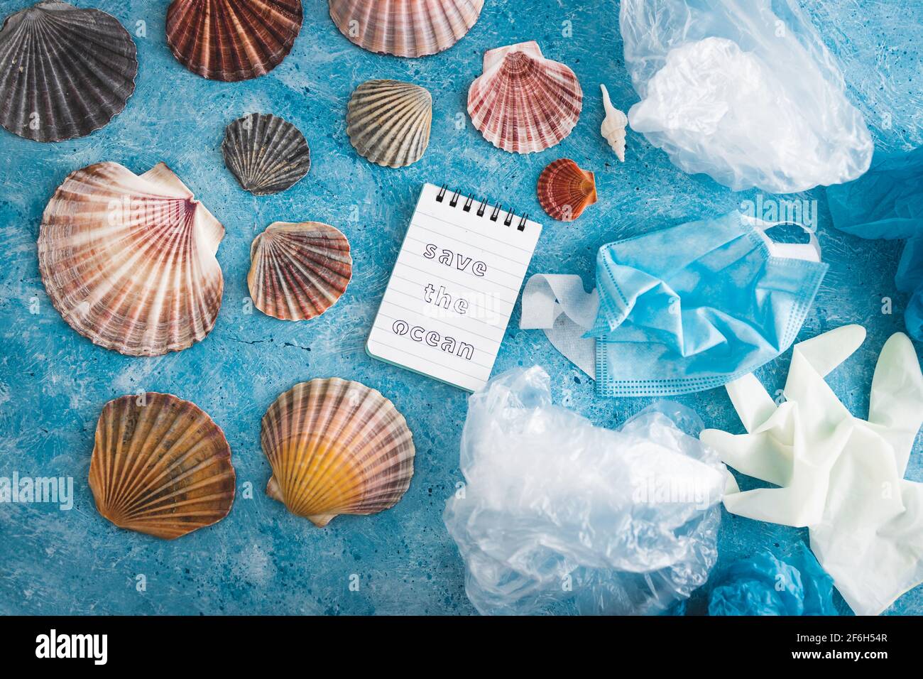 save the ocean text on blue bakground with sea shells and plastic ...