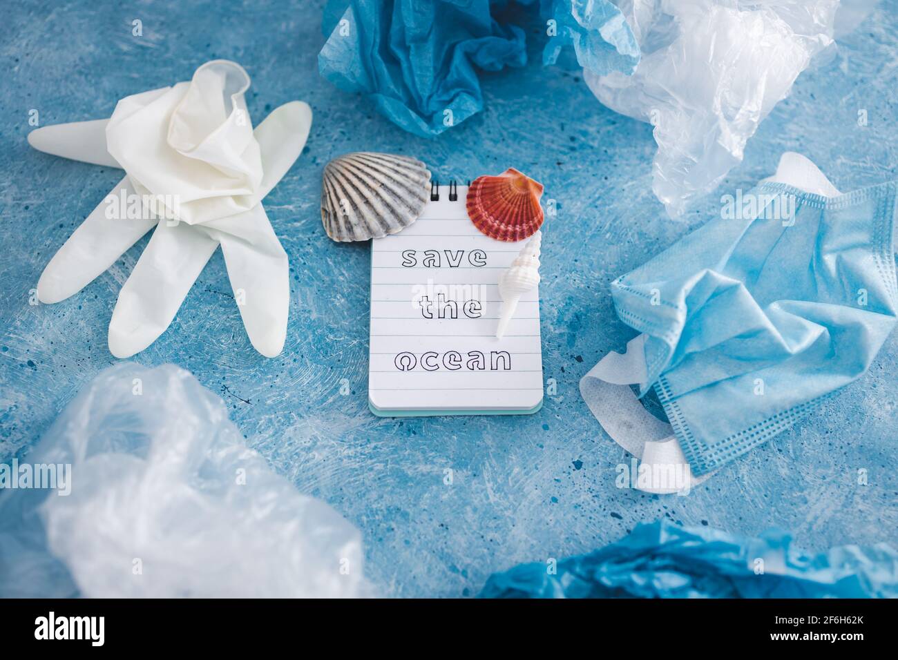 save the ocean text on blue bakground with sea shells and plastic ...