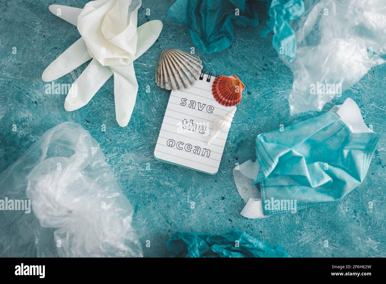 save the ocean text on blue bakground with sea shells and plastic ...