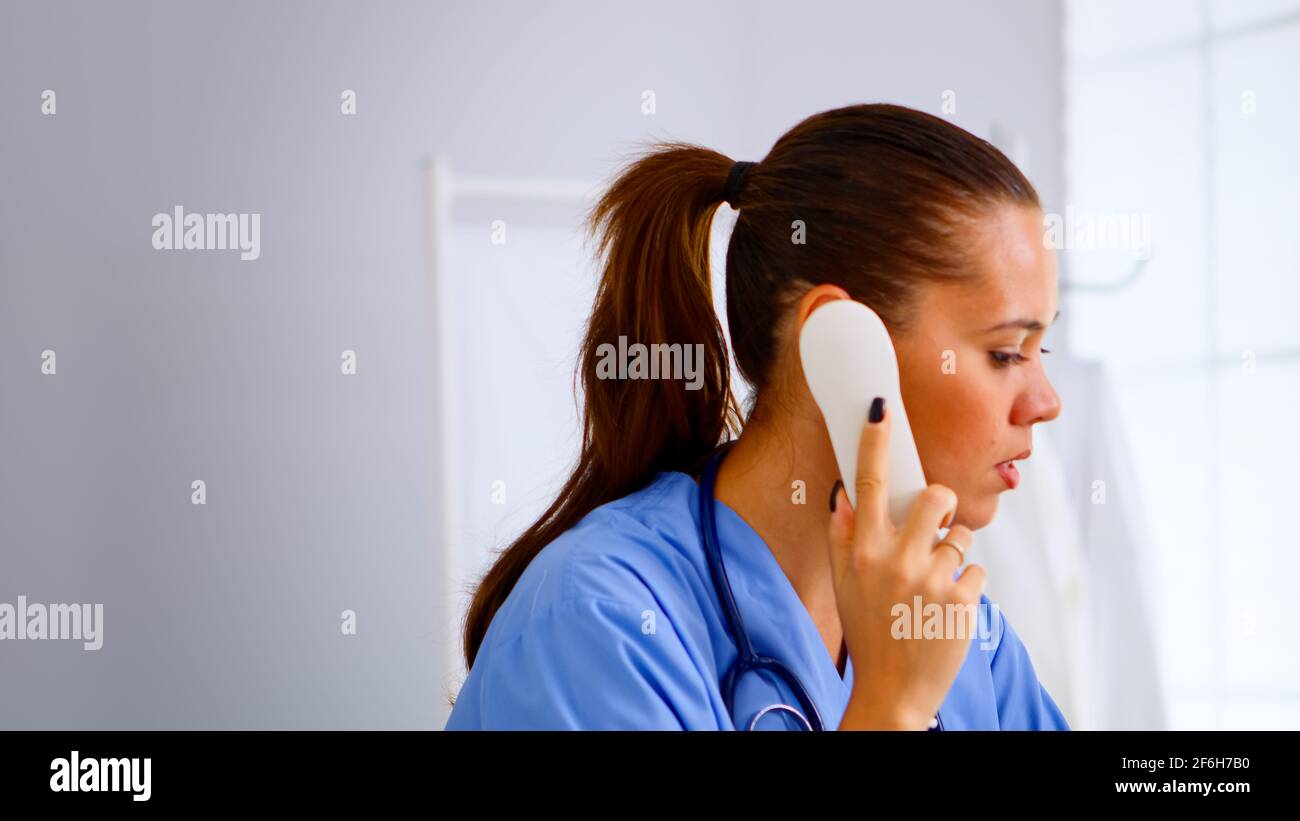 Medical receptionist answering phone calls from patient in hospital ...