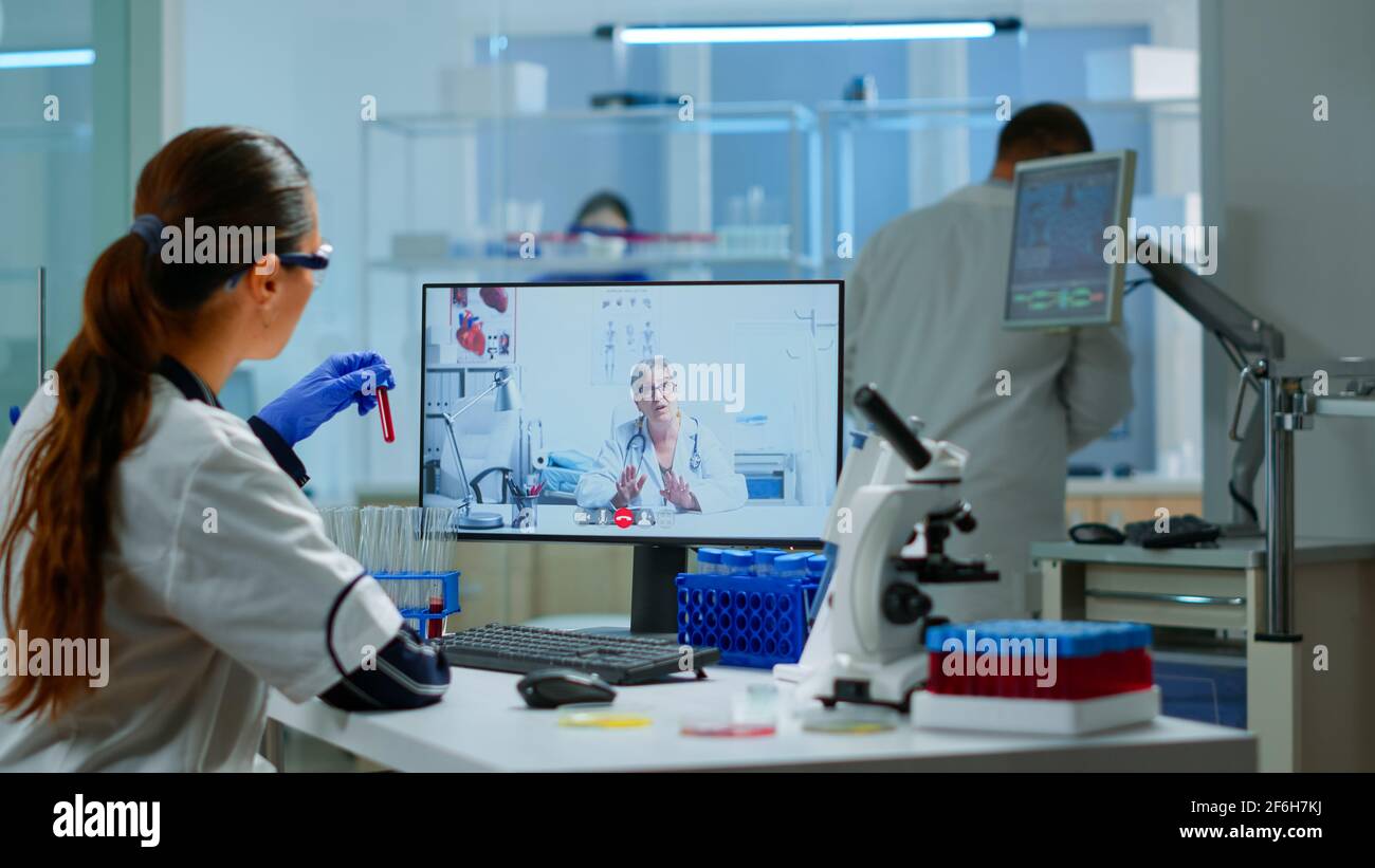 Scientist listening professional doctor on video call, discussing ...