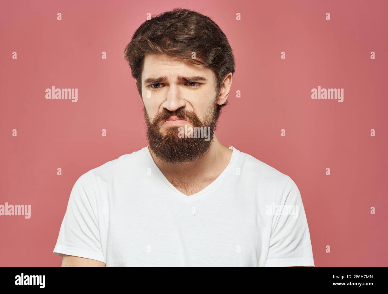 Man on pink background emotions model cropped view puzzled look sad ...