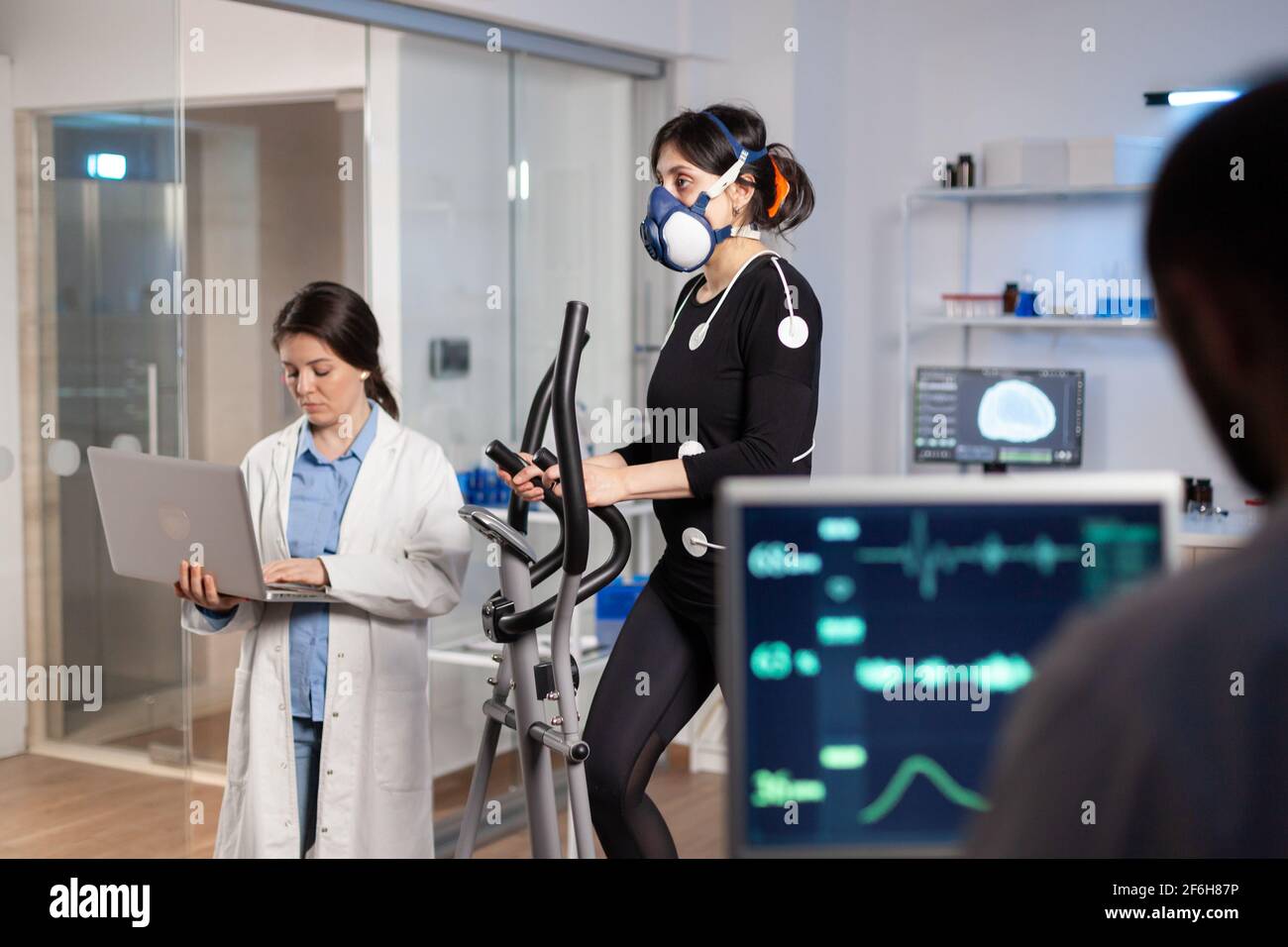 Team of medial researchers monitoring vo2 of woman performance sports ...