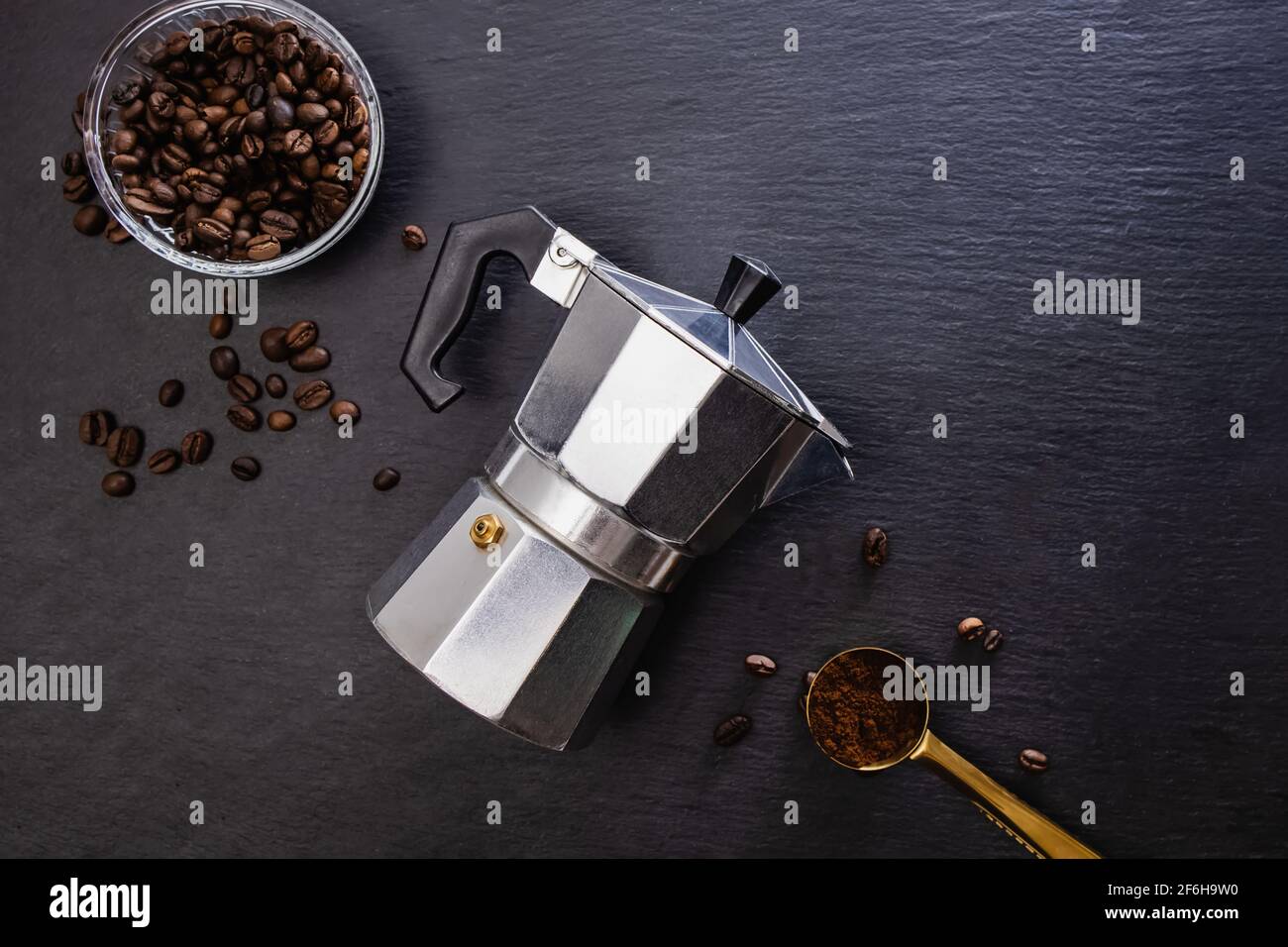 Still life with moka pot and coffee beans on black stone background ...