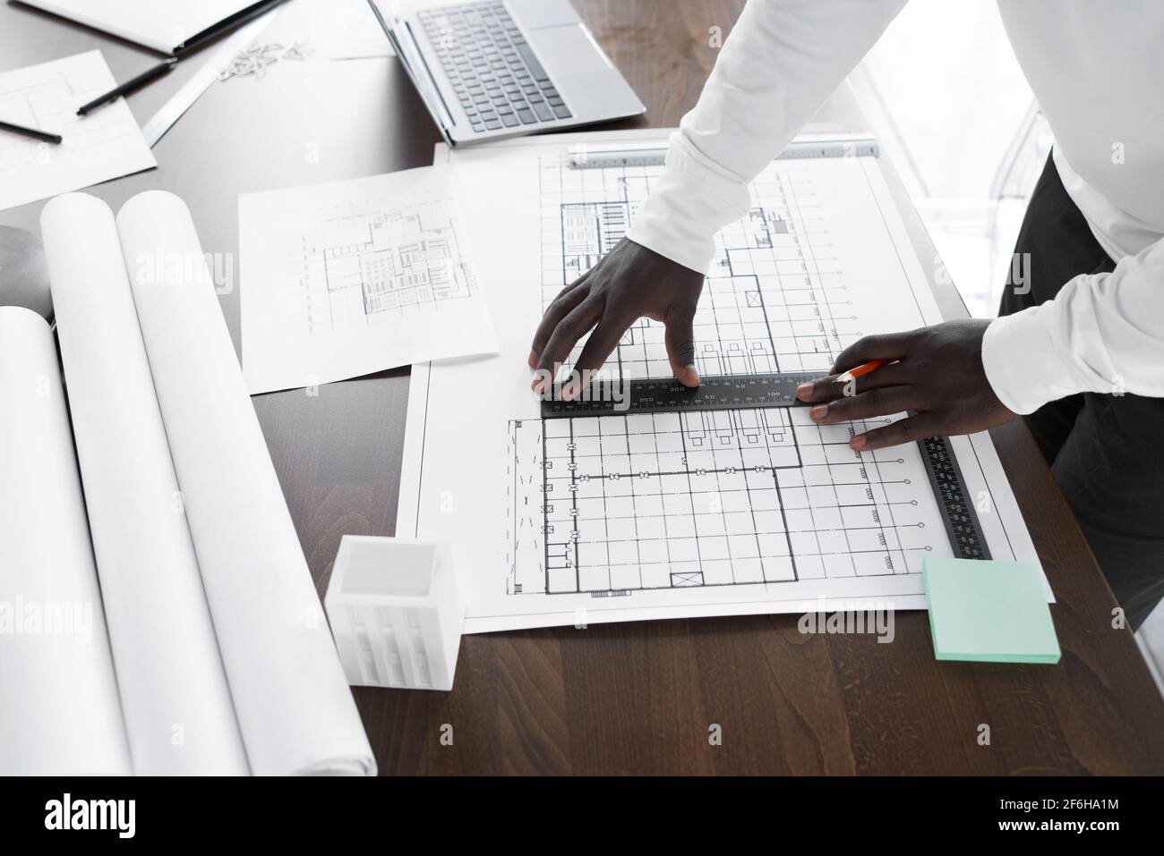 Close-up of African architect using pencil and ruler and drawing ...