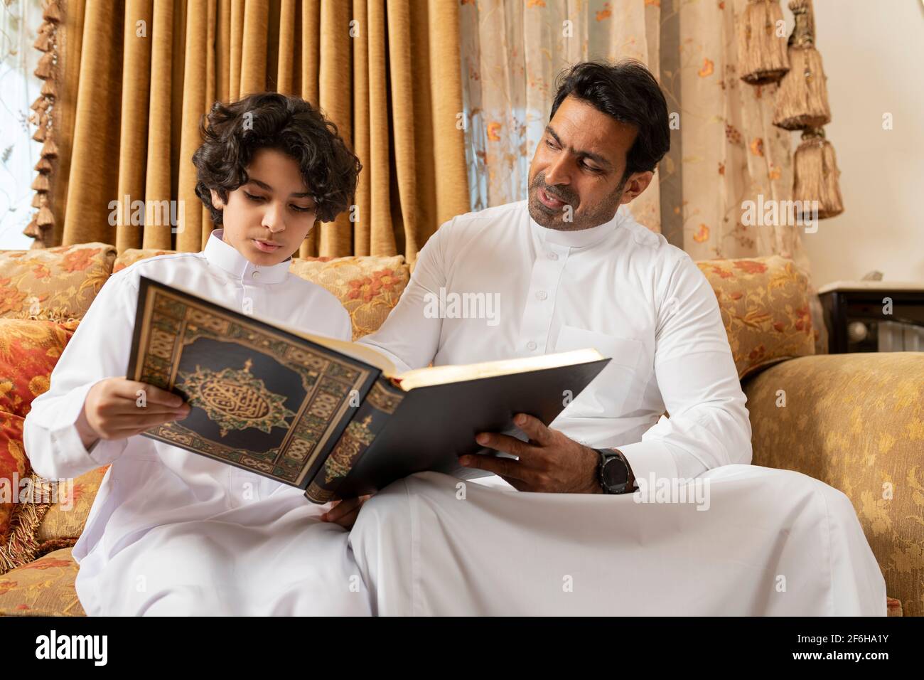 Arabian Father and Son reading Quran Holy Book Stock Photo - Alamy