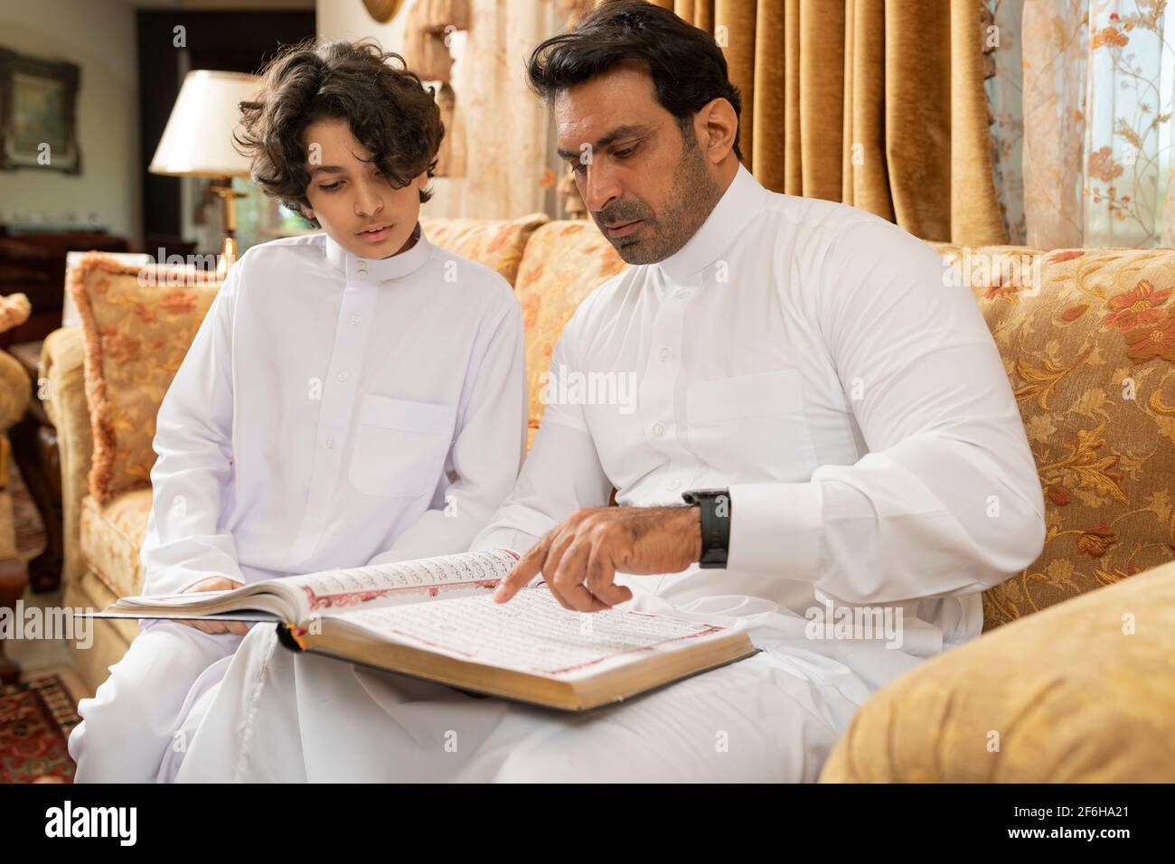 Arabian Father and Son reading Quran Holy Book Stock Photo - Alamy