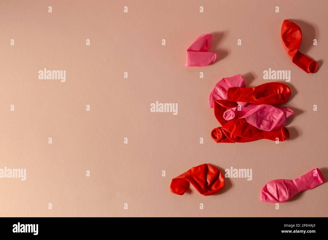 Minimalistic composition with deflated balloons on a pink background ...
