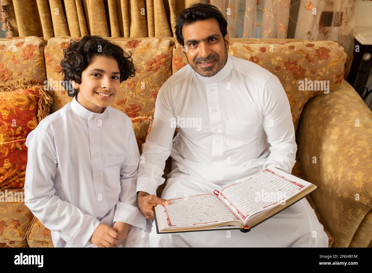 Arabian Father and Son reading Quran Holy Book Stock Photo - Alamy