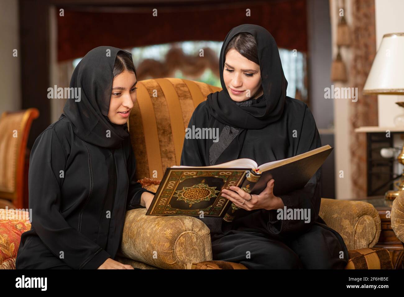 Arabian woman and daughter reading Islamic Holy book "Quran Kareem ...