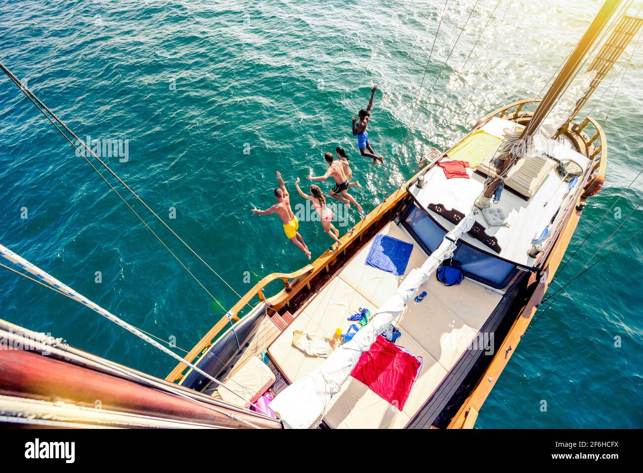 Aerial view of young people jumping from sailing boat on sea trip ...