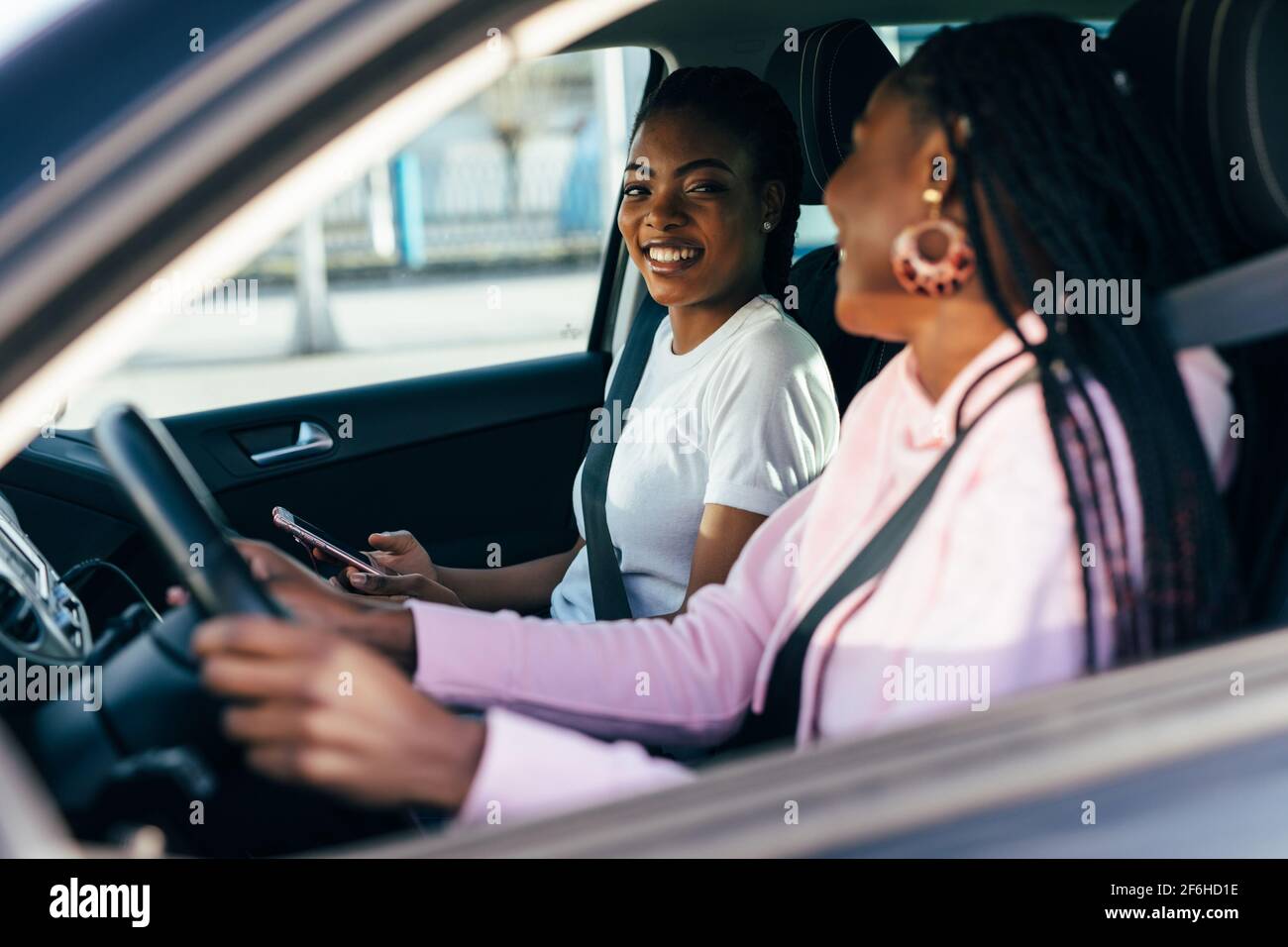 Two beautiful and pretty african women driving in car of their dream ...