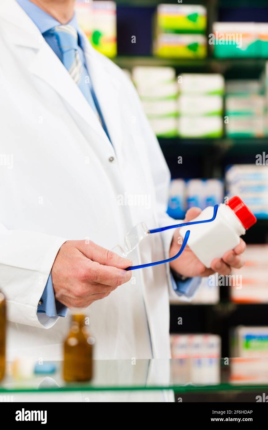 Pharmacist - only hands to be seen - standing in pharmacy with ...