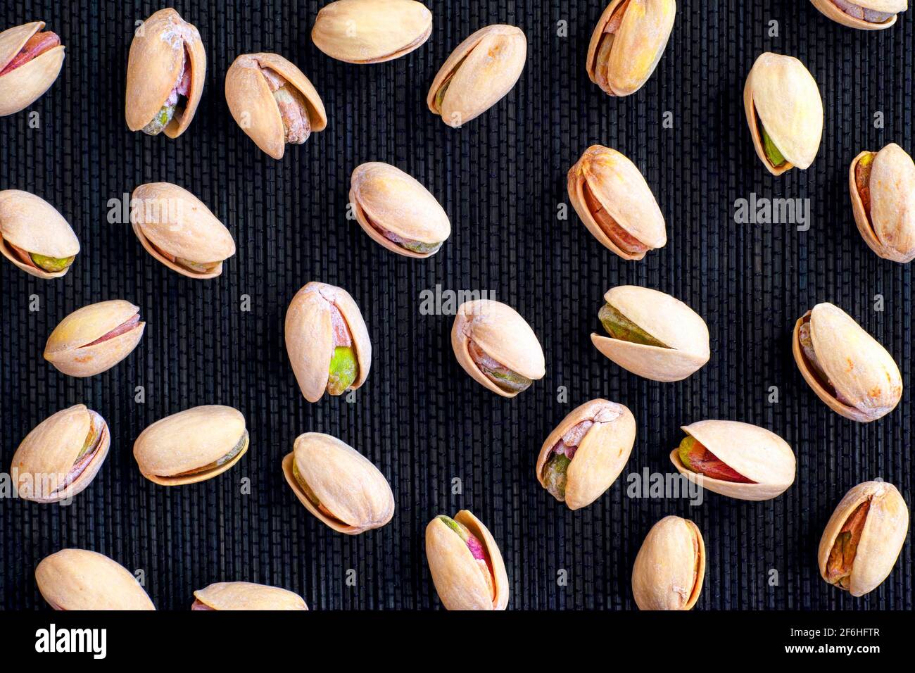 Pistachio nuts on black bamboo napkin background. Full frame Stock ...