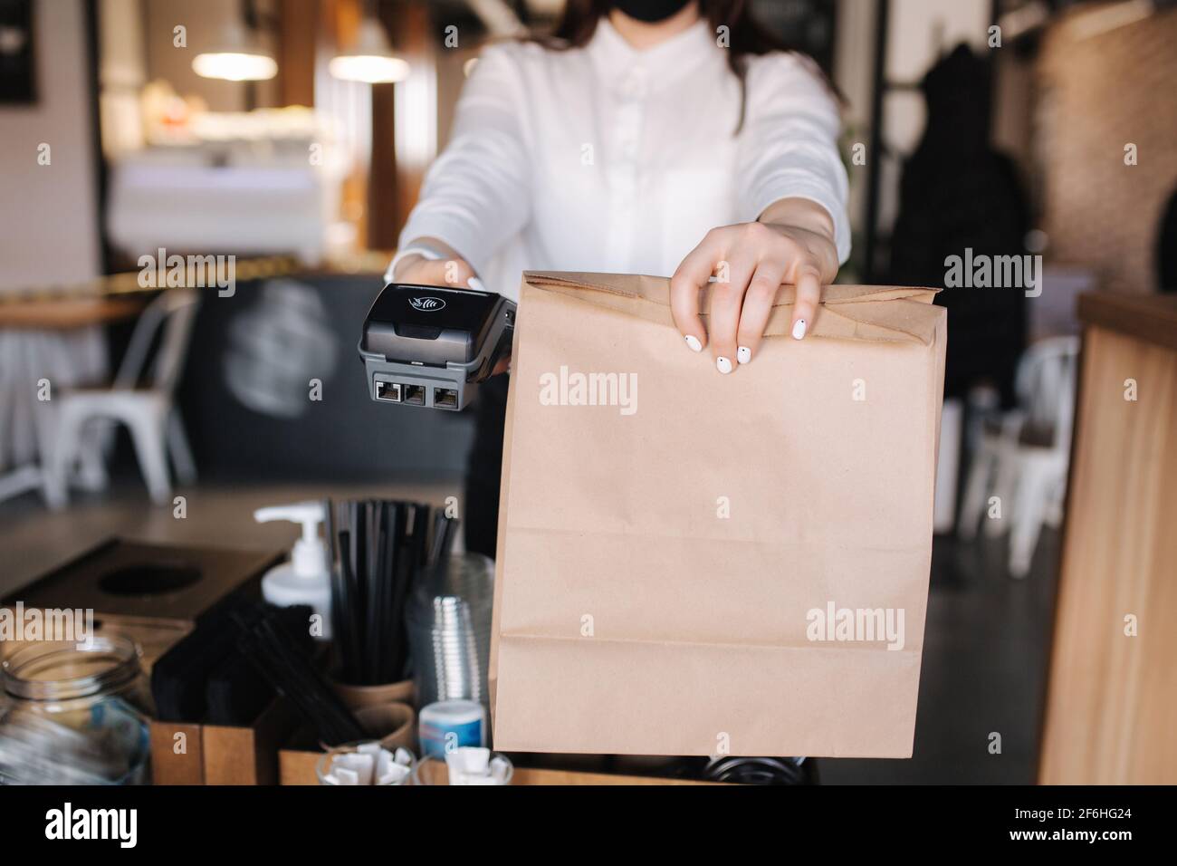 Cashier hand holding credit card reader machine and package with food ...